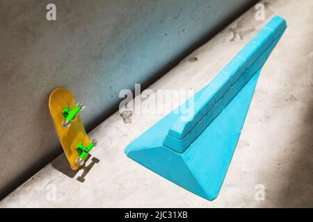 Yellow fingerboard and plaster ramp on a blue background Stock Photo ...
