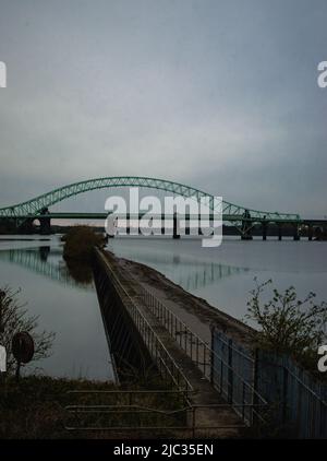 Silver Jubilee Bridge at Runcorn reflected in the River Mersey in black ...