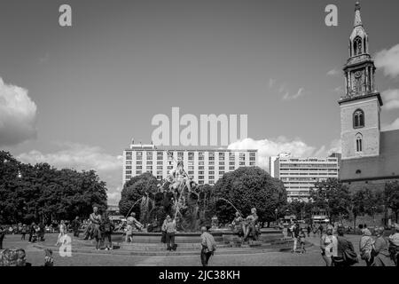 many people cavort at the famous Neptun fountain in Berlin in Black and ...