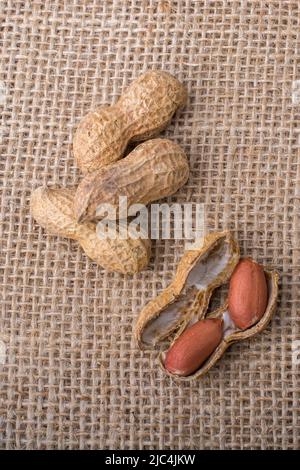 Cracked open peanuts with shell on a linen canvas background Stock ...