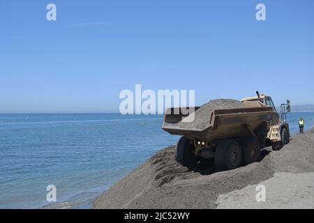 Truck unloading sand together a beach. Beaches generations works Stock ...