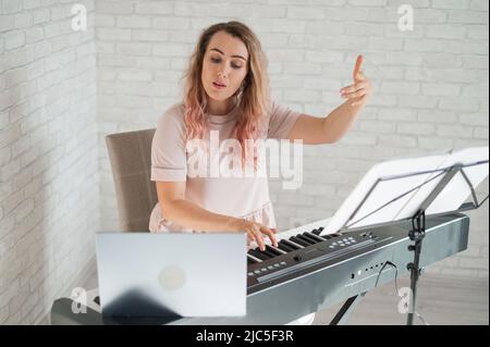 Remote music lessons. A singing teacher records the lesson on a laptop ...