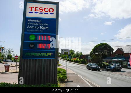 Axminster, Devon, UK. 10th June 2022. A motorist filling up two large ...