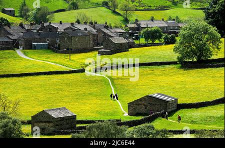 Muker, Yorkshire Dales, UK. 10th Jun 2022. Ramblers make their way ...