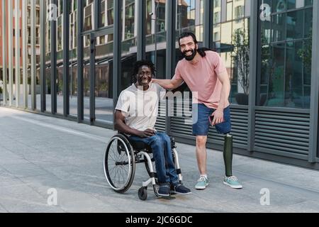 Multiracial friends looking at camera and smiling while sitting ...