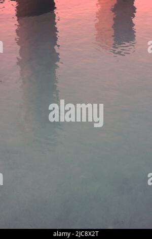 Simple and plain columns reflecting in the surface of the swimming pool ...