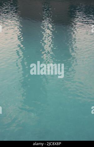 Simple and plain columns reflecting in the surface of the swimming pool ...