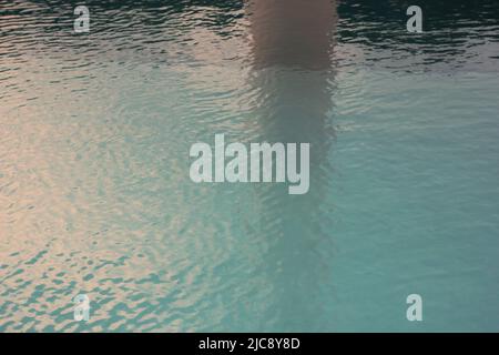 Simple and plain columns reflecting in the surface of the swimming pool ...
