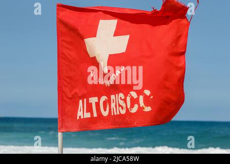 red current signaling flag, written high risk on a beach in Rio de ...