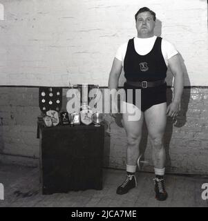 1957, historical, weight-lifting, inside a gym on a wooden board, a ...