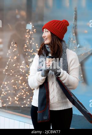 An Asian female in white sweater holding mobile phone, using her ...