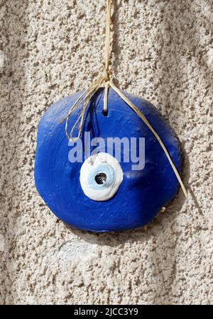 Blue evil eye bead on a pink background Stock Photo - Alamy