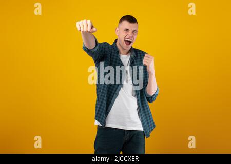 Overjoyed caucasian man shouting and shaking fists, celebrating big ...