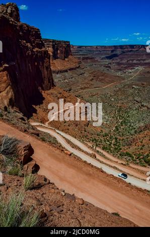 Dirt road at the bottom of the canyon among the layered geological ...