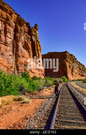 Railroad at the bottom of a canyon next to Layered Geological ...