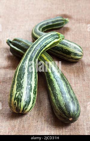 Fresh striped zucchini on sackcloth background with copy space Stock ...