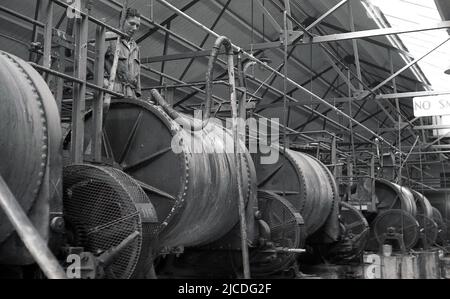 1960s, historical, inside a paint manufacturing factory, a male ...