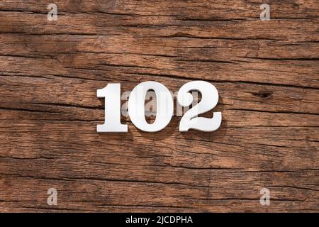 Number 102 in wood, isolated on white background Stock Photo - Alamy