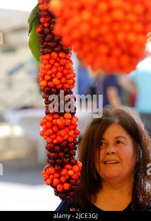 Hammana, Lebanon. 12th June, 2022. A woman shows a cherry hat at the ...