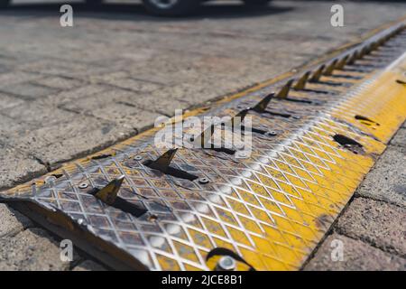 One way yellow traffic spikes at parking lot exit Stock Photo - Alamy
