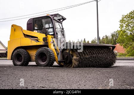 Cleaning of garbage from the road. a rotating mechanical machine brush ...