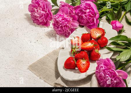 Sweet ripe strawberries and fragrant peonies bouquet. Summer plaster ...