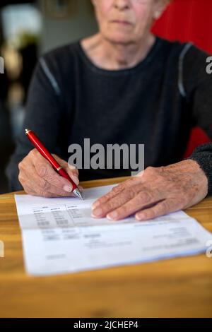 Closeup woman's hands writing bank cheque on green background Stock ...