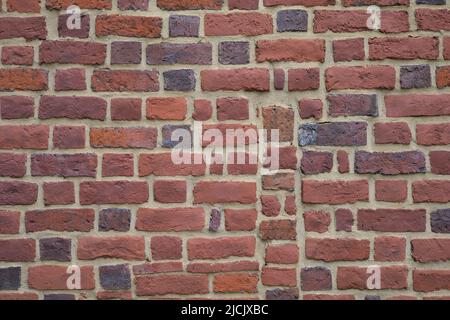 A wall with the red bricks and black cement or outline that puts the ...