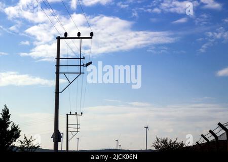 A concrete electric pole with steel cables in blue sky with copy space ...