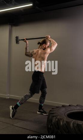 Crossfit sledge hammer man at gym relaxed Stock Photo - Alamy