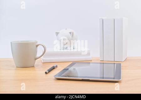 Apple ipad tablet with books stylus pen and mug on a bright wooden desk ...