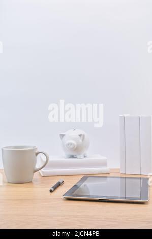 Apple ipad tablet with books stylus pen and mug on a bright wooden desk ...