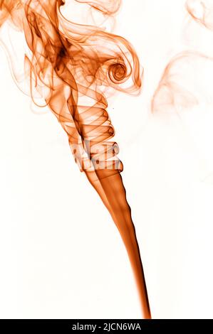 Puffs and curls of dark smoke on a white background rising from a ...