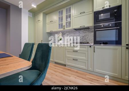 Modern light green luxurious kitchen with dining table Stock Photo - Alamy