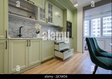 Modern light green luxurious kitchen with dining table Stock Photo - Alamy
