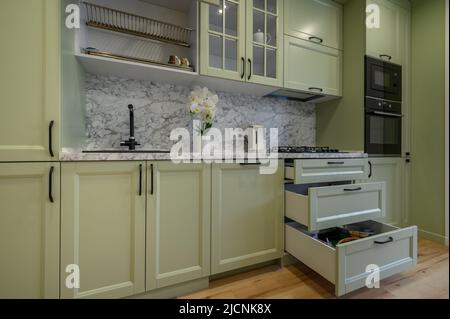 Modern light green luxurious kitchen with dining table Stock Photo - Alamy
