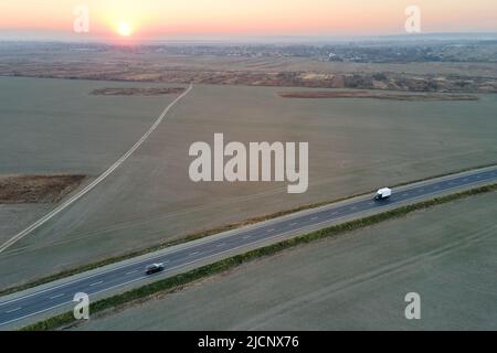 Aerial view of intercity road with fast driving cars between autumn ...