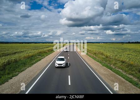Aerial view of intercity road with fast driving cars between autumn ...