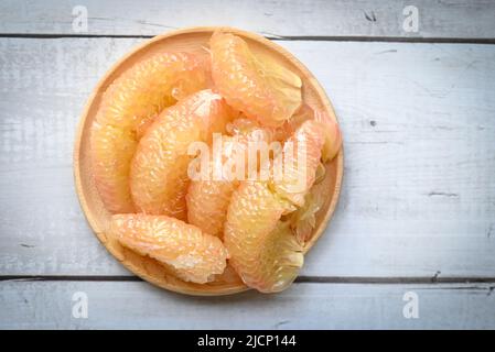 Top view of fresh peeled pomelo on bright wooden table background for ...