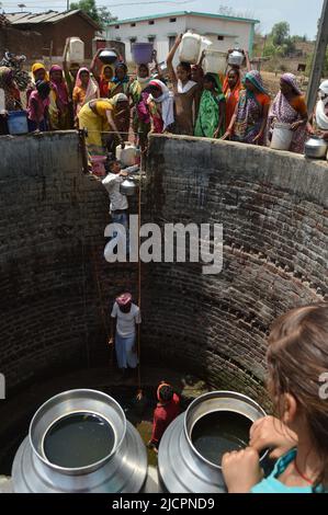 Indian people of an aboriginal 'Kol' community refill drinking water in ...