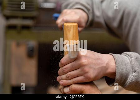 Closeup of carpenter cutting table leg with hand saw Stock Photo - Alamy