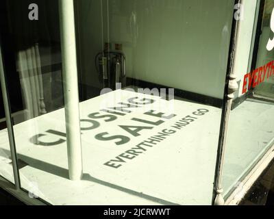 Store closing sale sign with shadow in high street shop window display ...