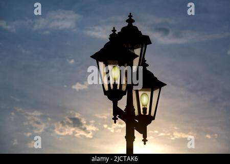 triple lantern head with transparent glass panels and electric bulb ...