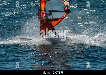 Windsurfer is practicing on this beautiful windy spring day. He is ...