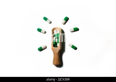 Green tablets in the wooden spoon, spirulina or chlorella food ...