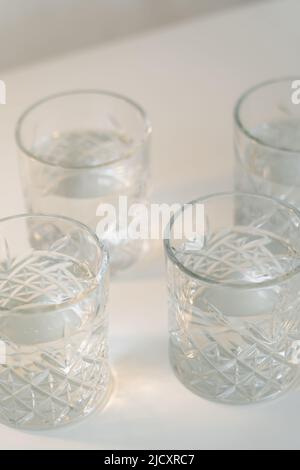 faceted glasses with water on grey background with copy space, banner ...