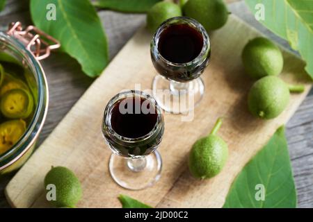 Macerating unripe walnuts in alcohol in a jar, to prepare homemade nut ...