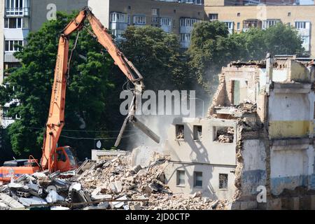 Construction equipment dismantle a destroyed building, by a Russian ...