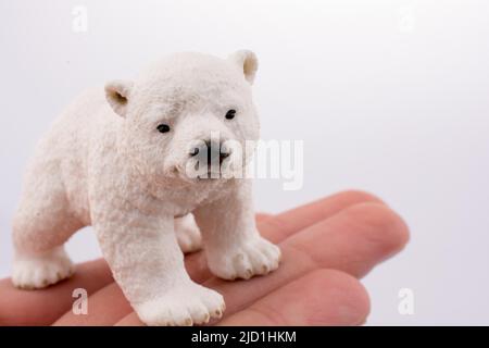 Hand holding a Polar bear model on a wooden background Stock Photo - Alamy