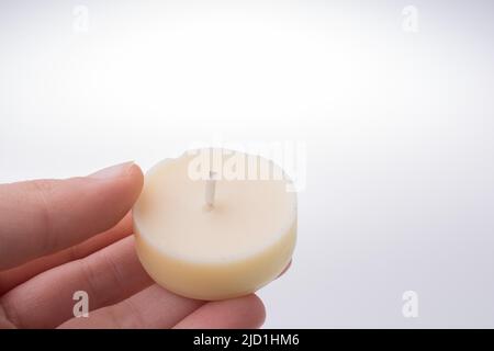 White color small Candle in hand on a brown background Stock Photo - Alamy